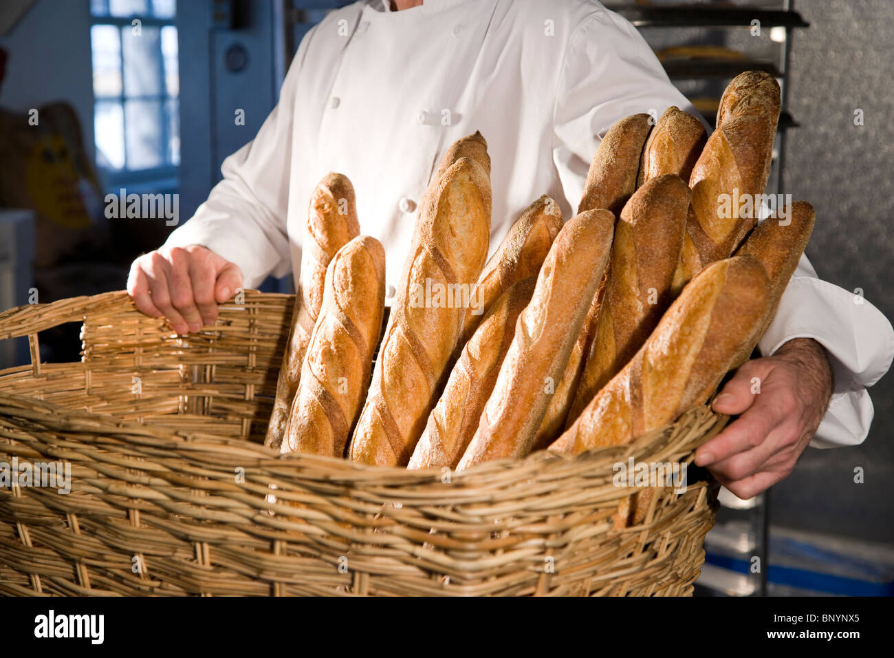 Baker carrying basket with loaves of freshly baked bread Stock Photo ...