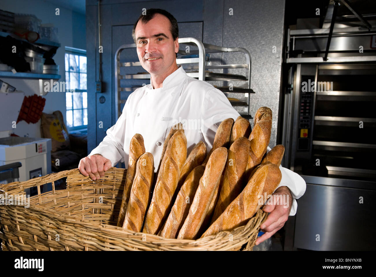 Baker carrying basket with loaves of freshly baked bread Stock Photo ...