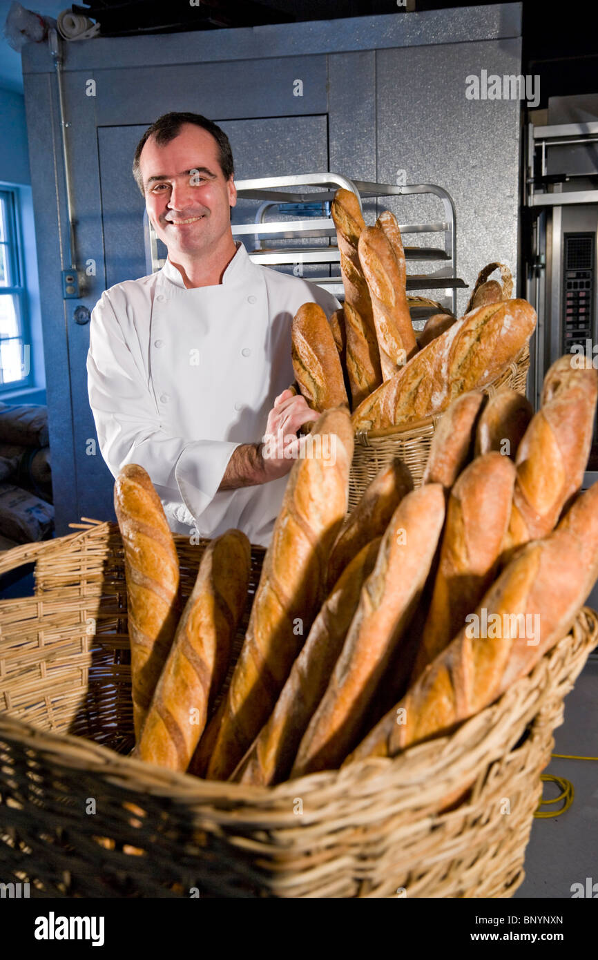 Baker carrying basket with loaves of freshly baked bread Stock Photo ...