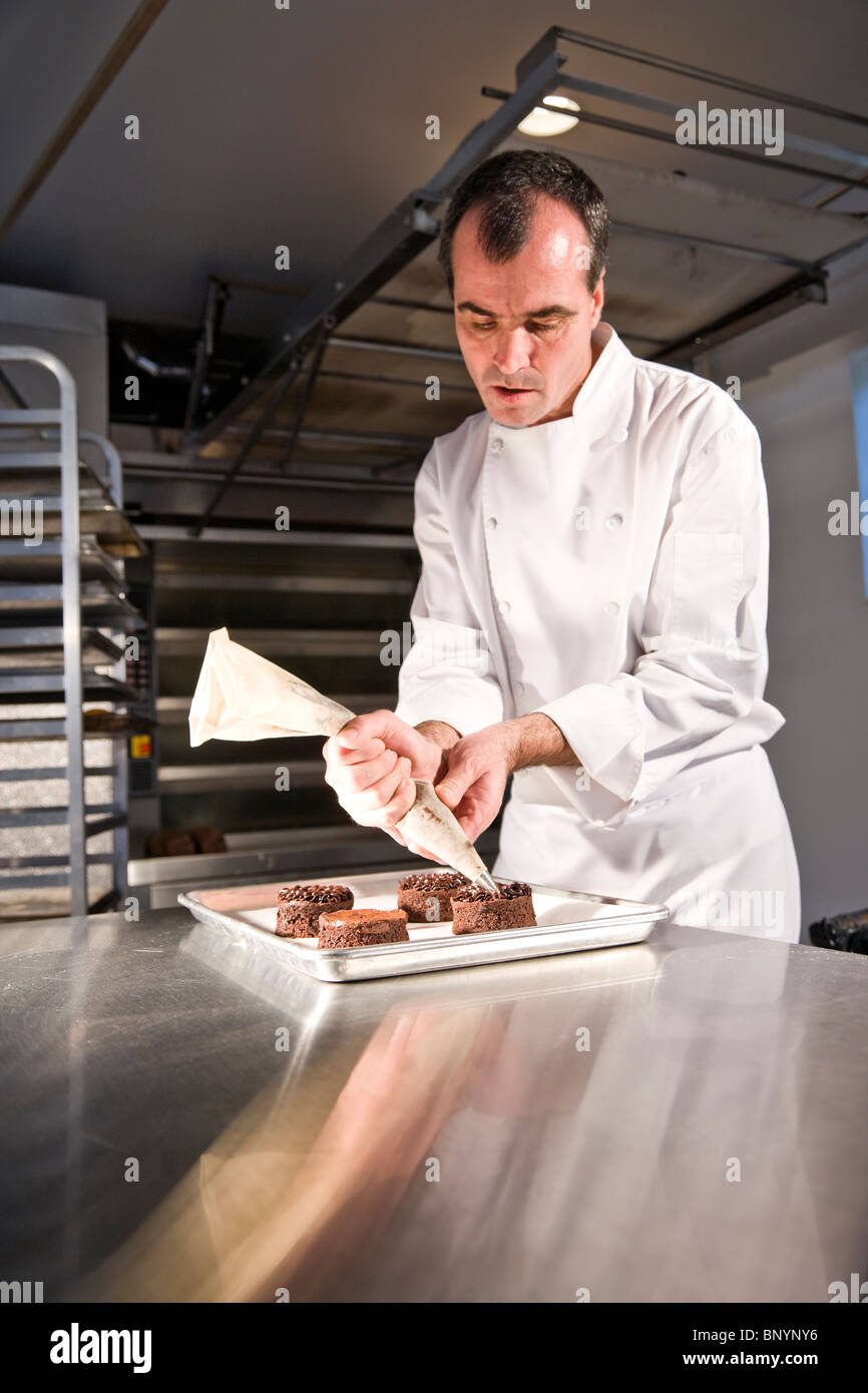 Pastry chef decorating chocolate dessert pastries Stock Photo - Alamy