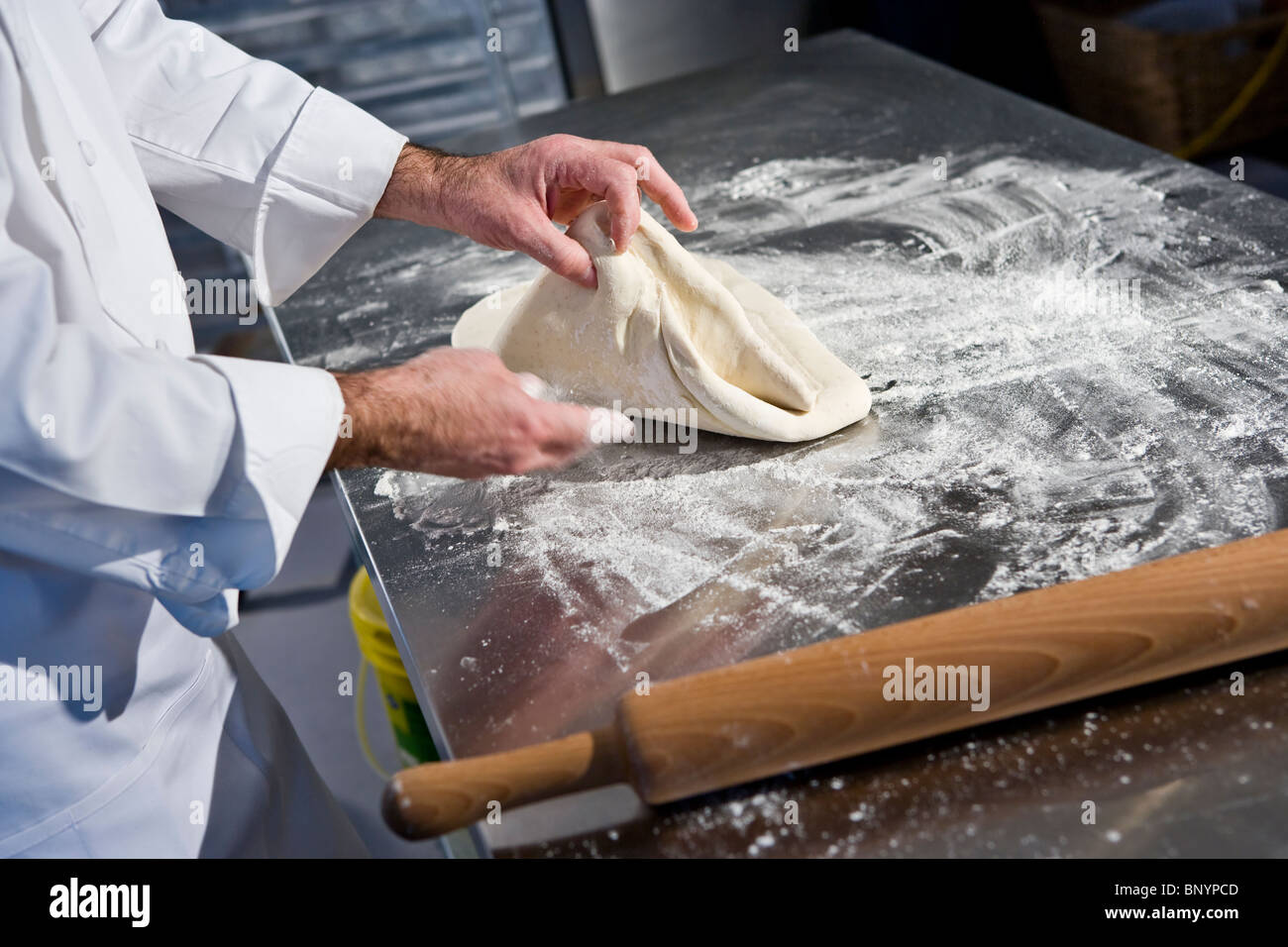 Professional baker rolling dough with pin Stock Photo - Alamy