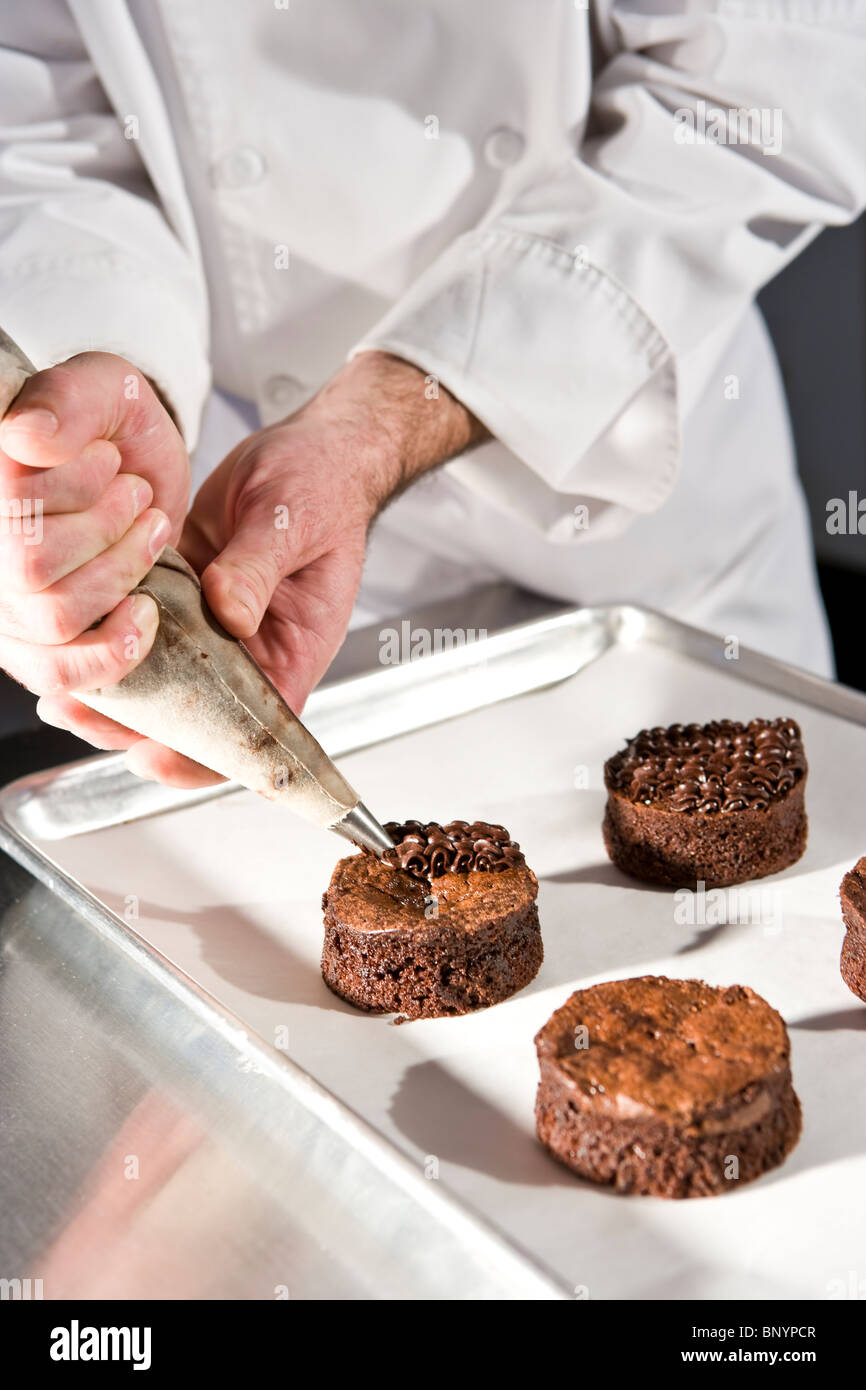 Cropped view of pastry chef decorating chocolate dessert pastries Stock ...