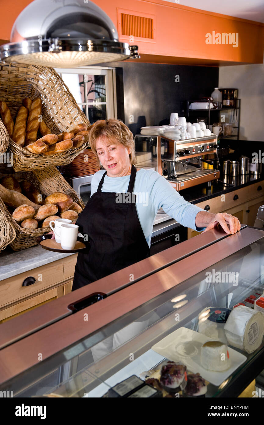 Waitress in restaurant standing behind counter Stock Photo - Alamy