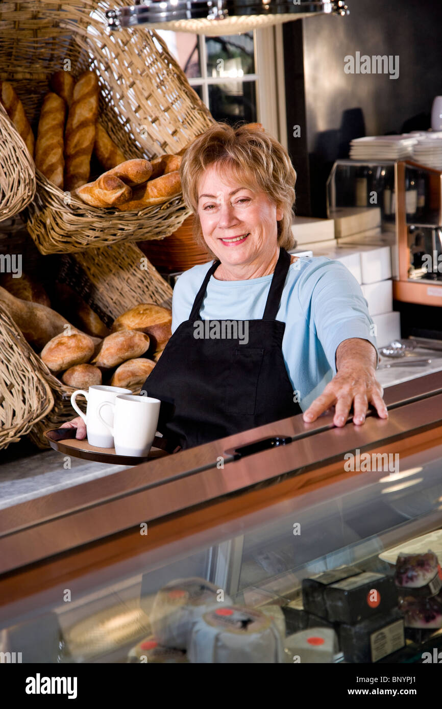 Waitress in restaurant standing behind counter Stock Photo - Alamy