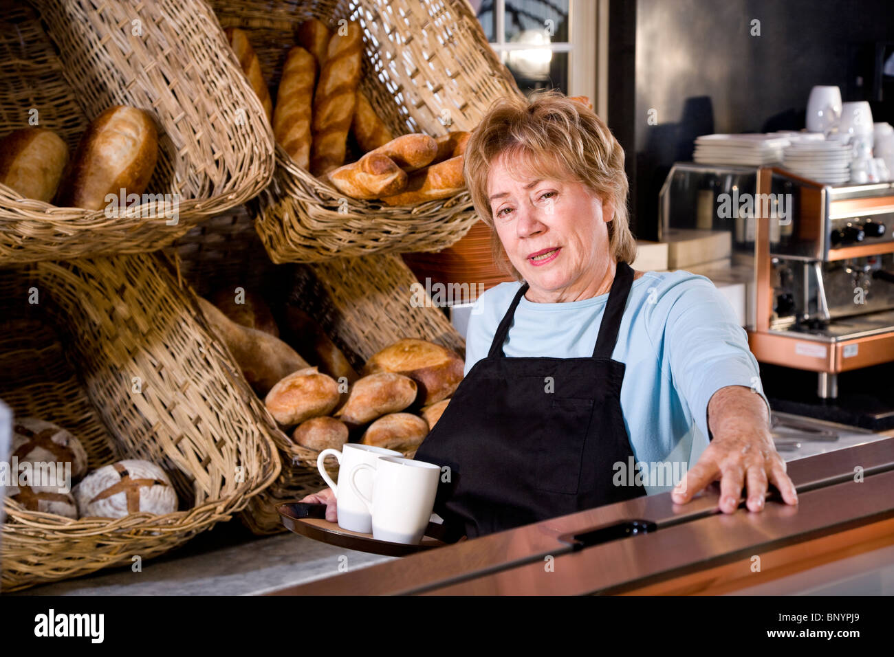 Waitress in restaurant standing behind counter Stock Photo - Alamy