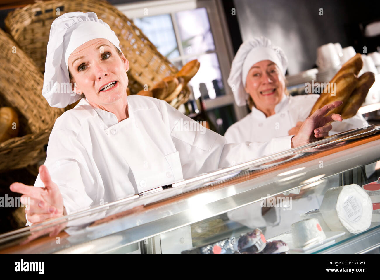 Bakers with loaves of bread behind bakery counter Stock Photo - Alamy