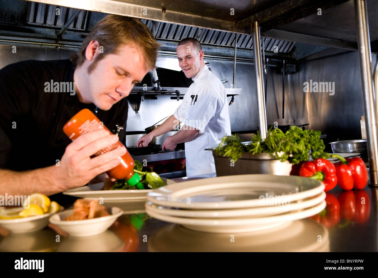 Sous chef in commercial kitchen preparing dishes Stock Photo - Alamy