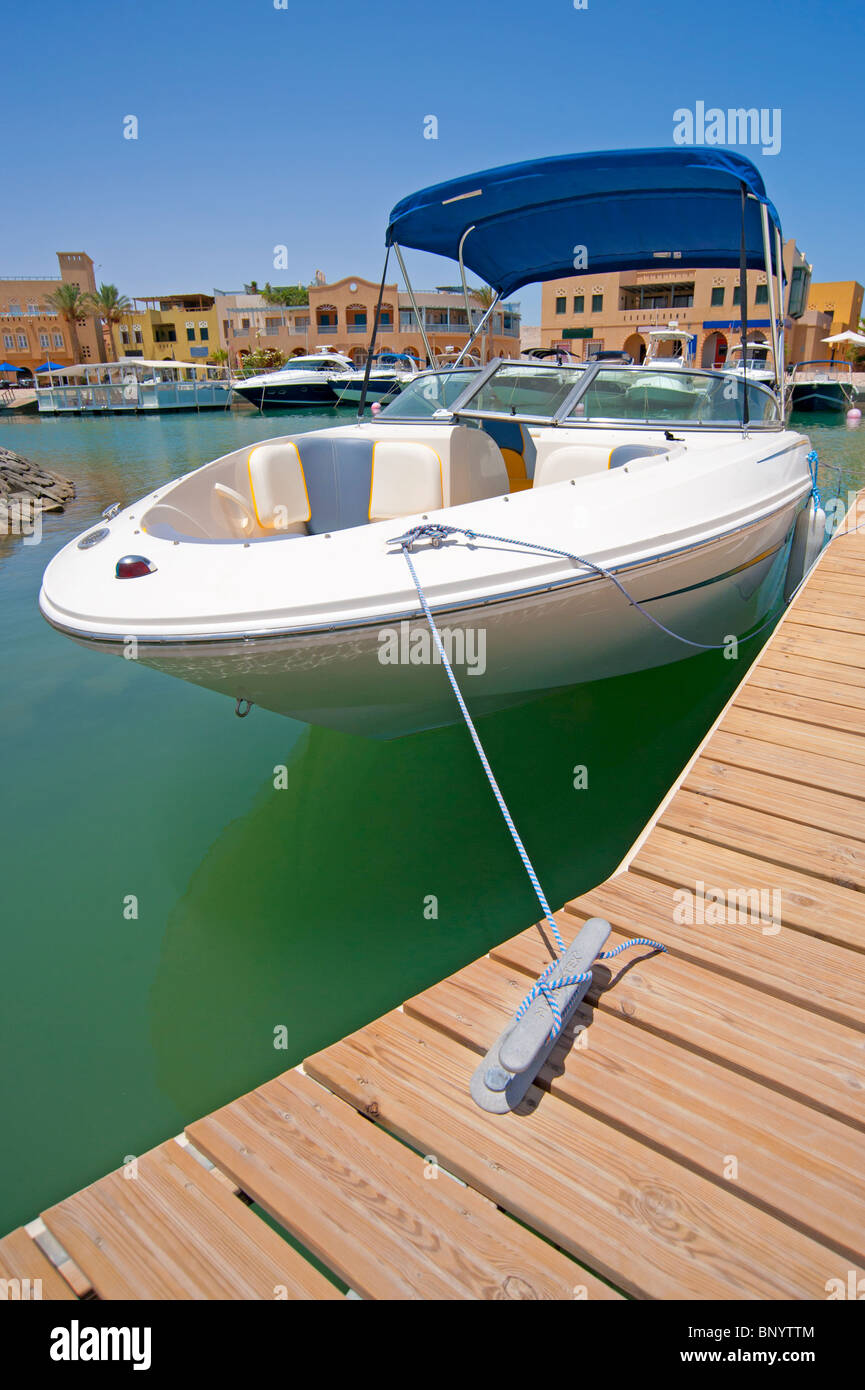 A luxury speedboat moored to a private jetty in a tropical marina Stock ...