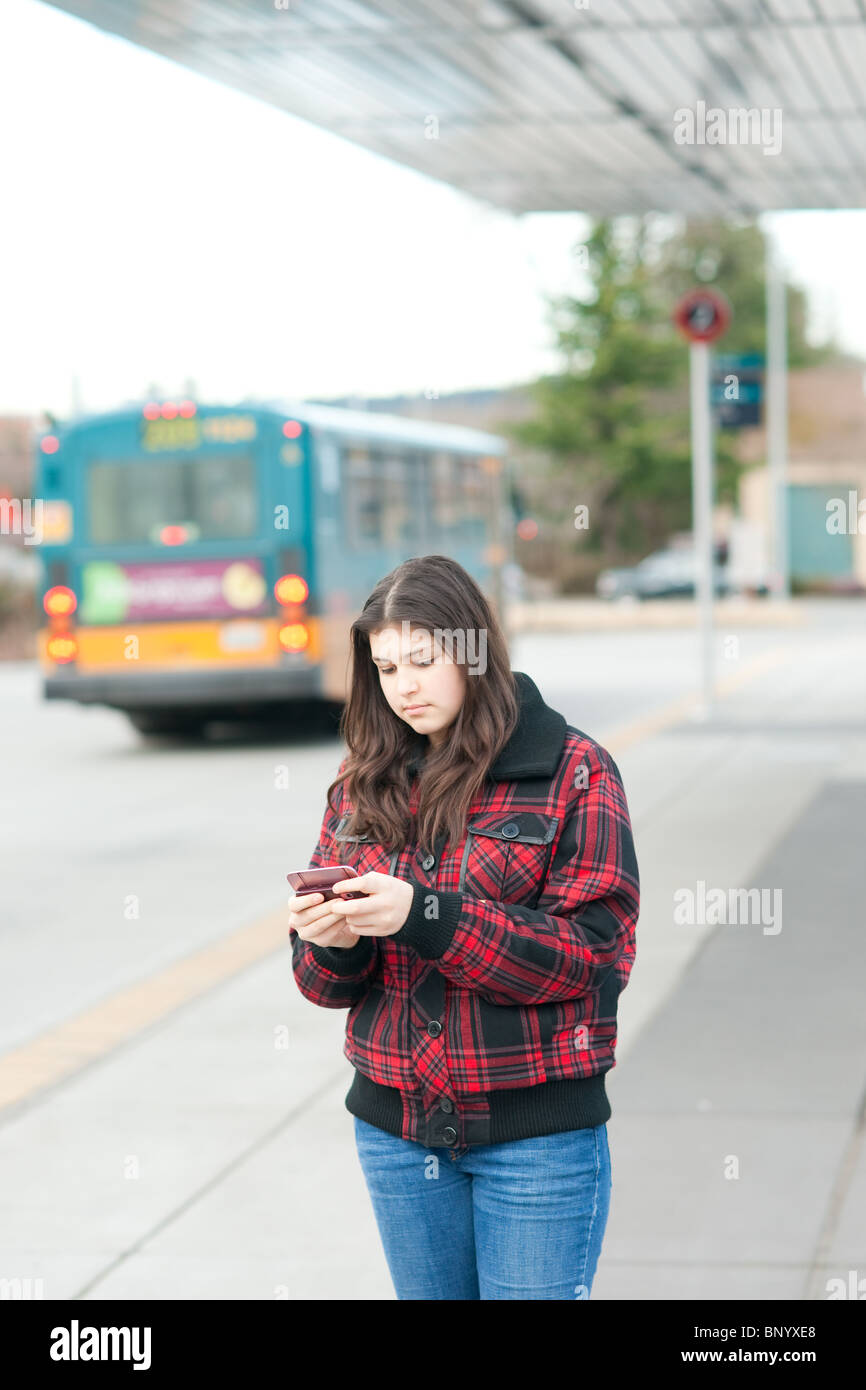 Young girl texting on bus stop. Shallow depth of field Stock Photo - Alamy