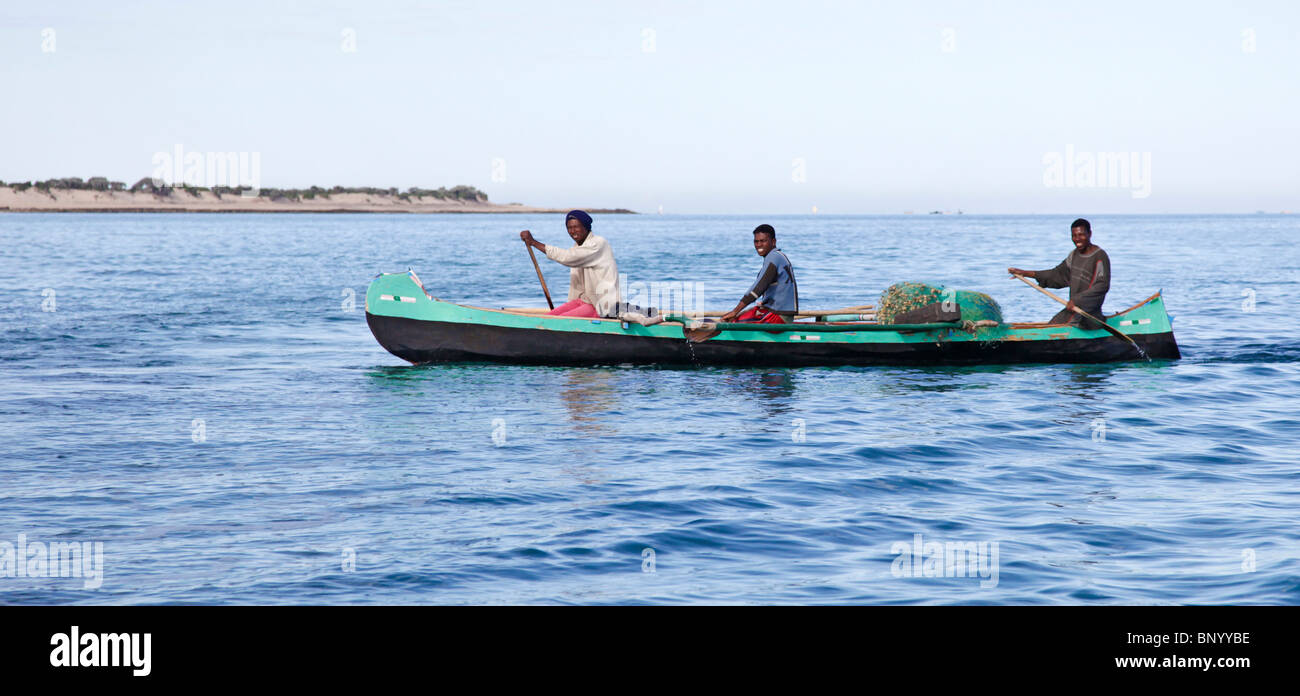 Three Vezo fishermen in their pirogue / outrigger canoe, off their ...