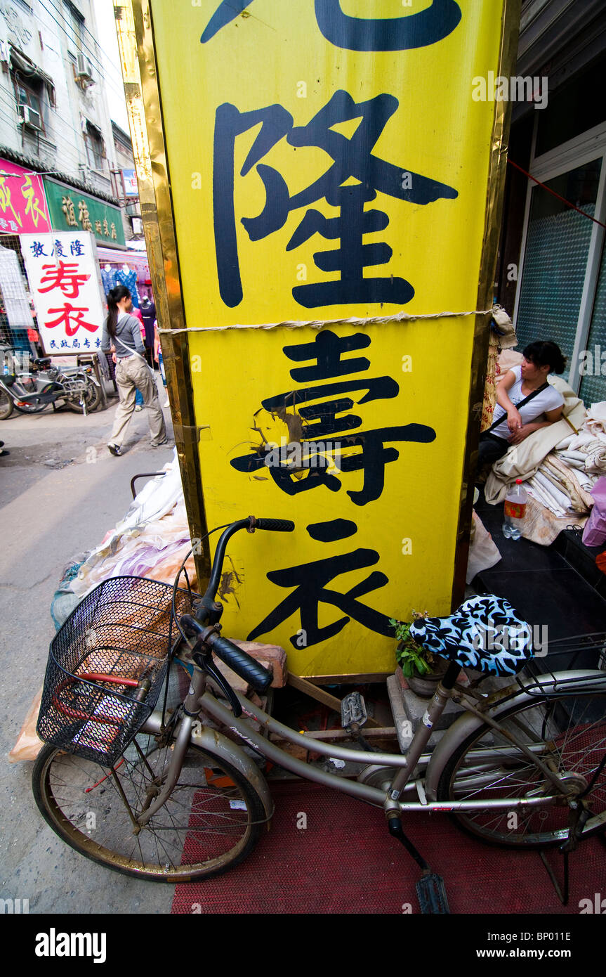Bicycle and a colorful shop sign in China Stock Photo - Alamy