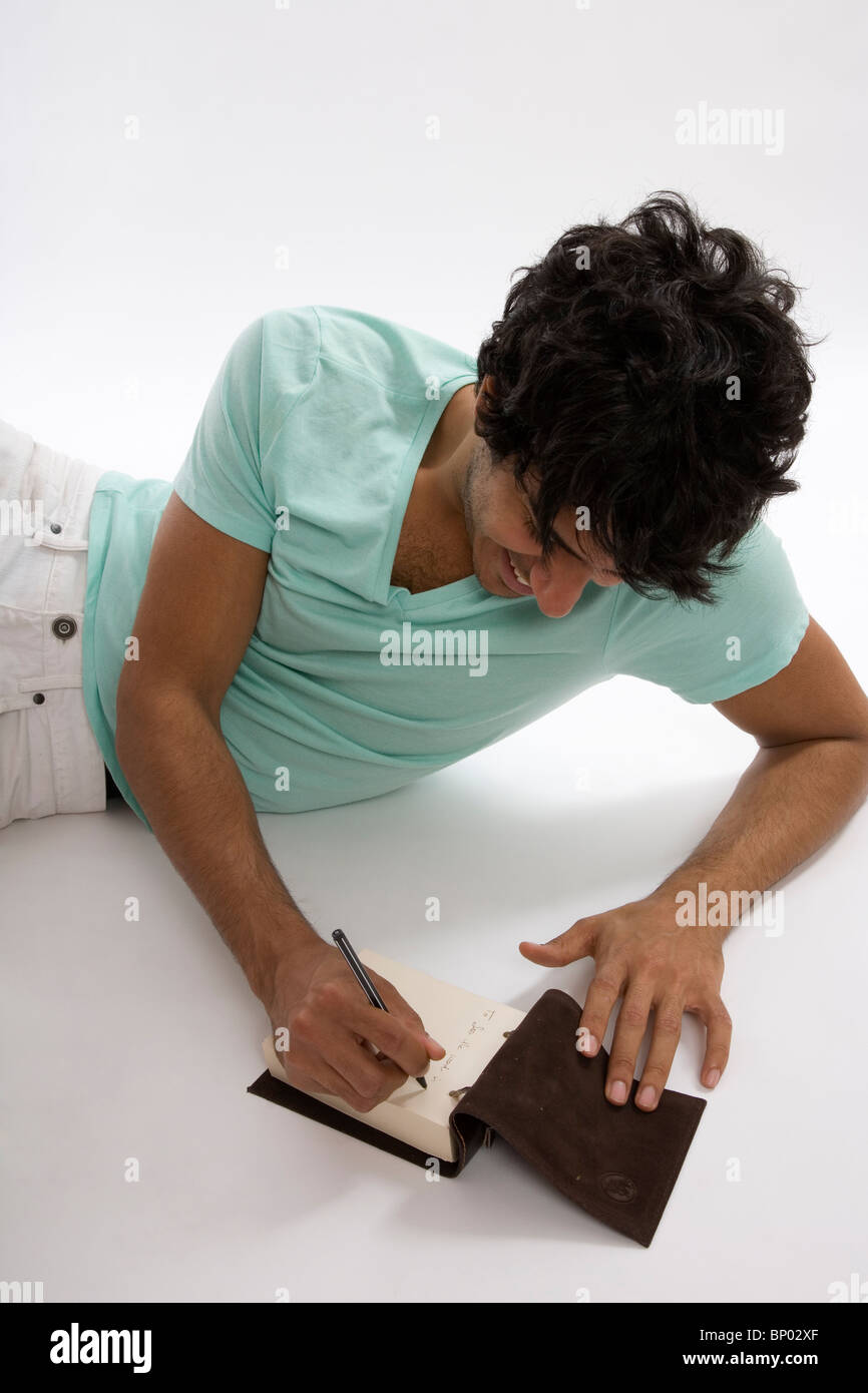 Male writing in notebook Stock Photo - Alamy