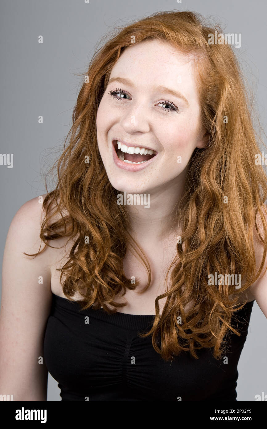 Shot of a Beautiful Red Headed Girl Smiling against Grey Background ...