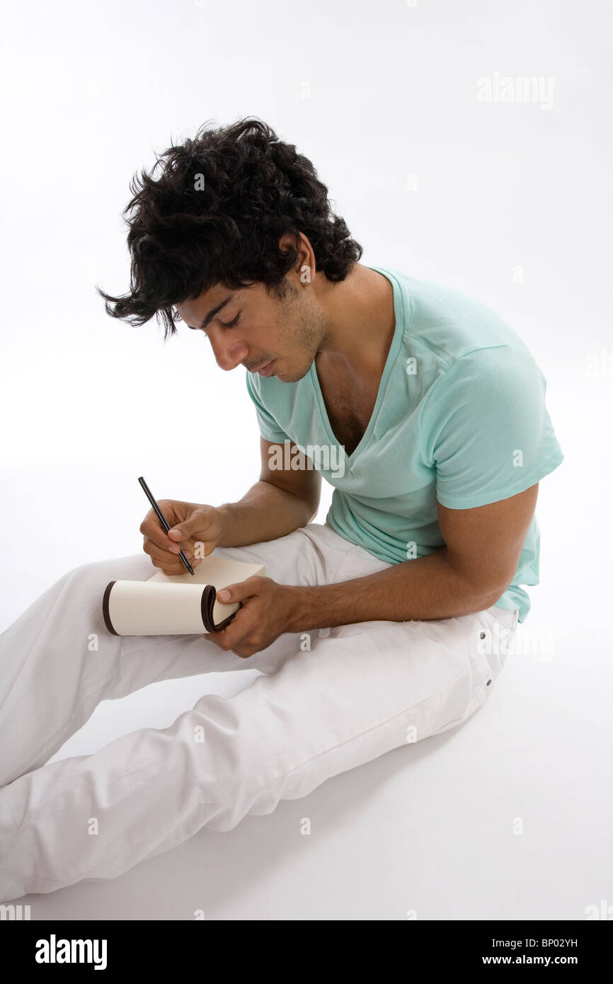 Male writing in notebook Stock Photo - Alamy