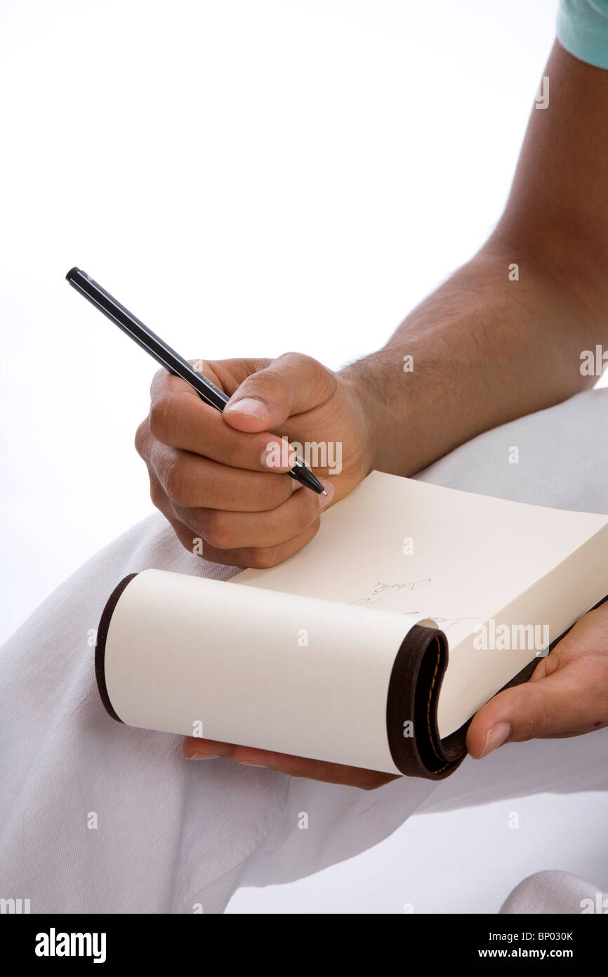 Male writing in notebook Stock Photo - Alamy