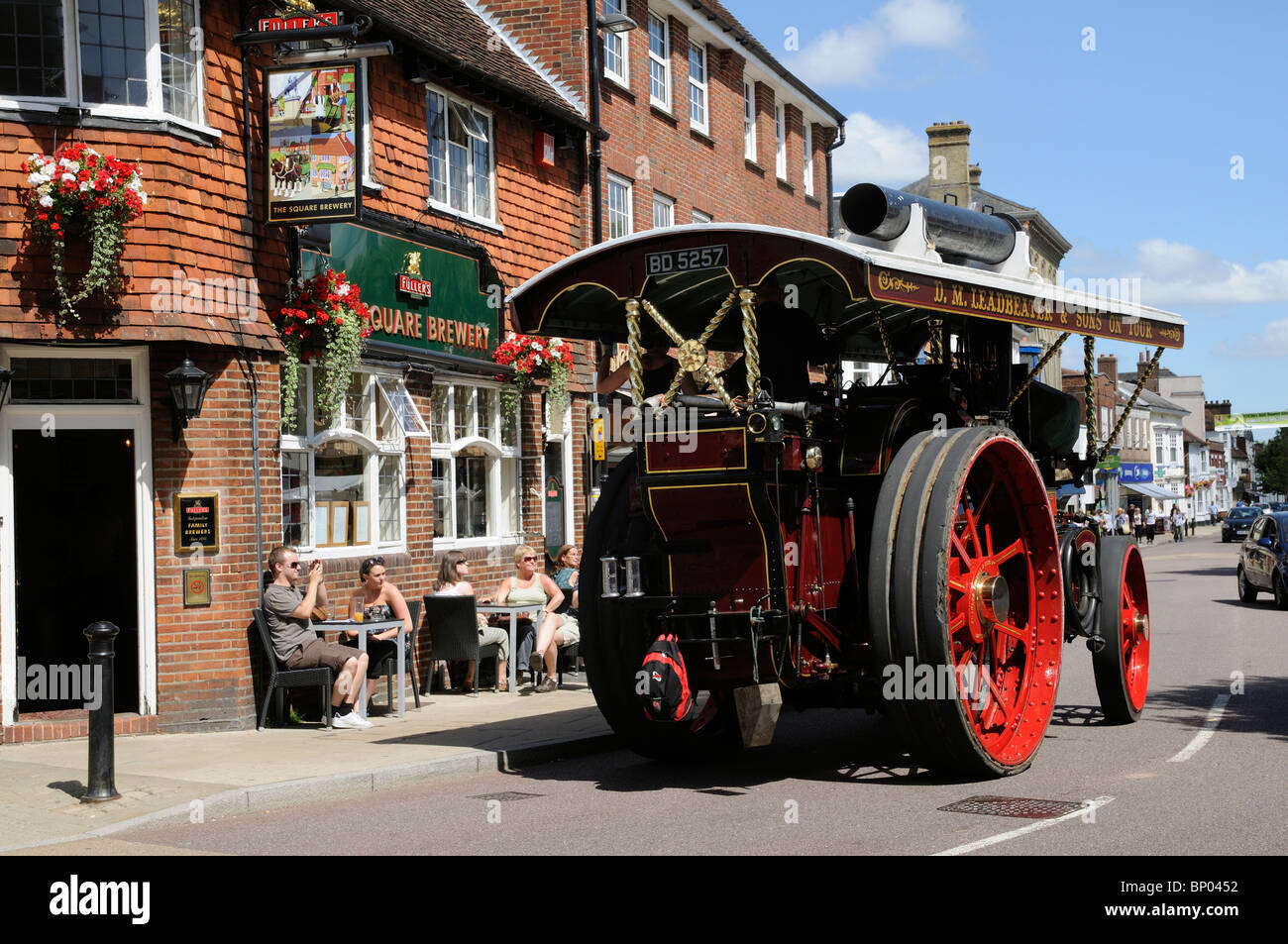 Steam traction engine passing a town centre pub in Petersfield a ...