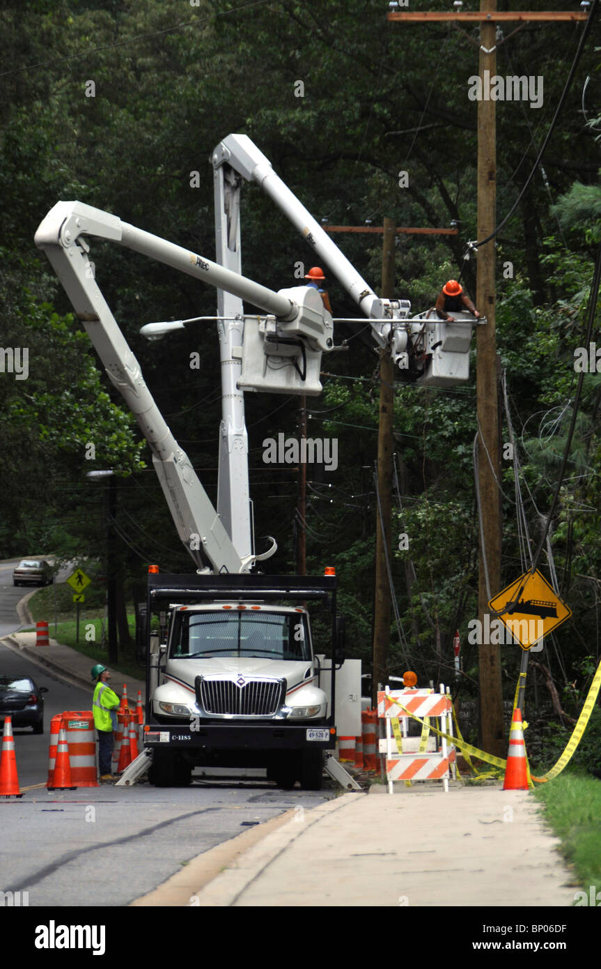 Utility workers repair damage done to an electrical pole damaged in a ...
