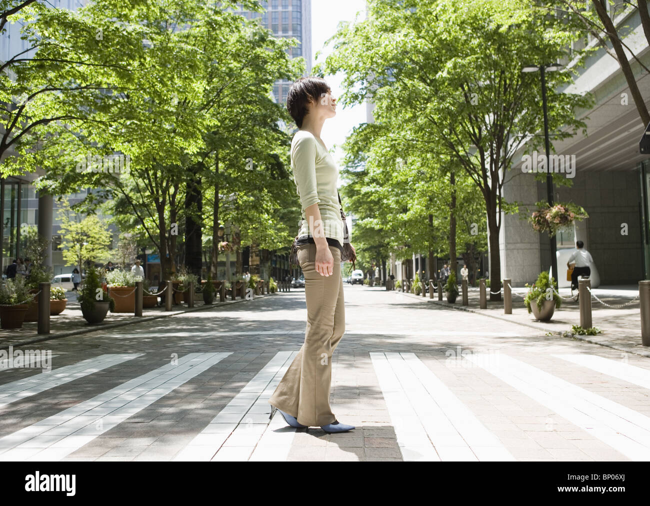 Young woman crossing at crosswalk Stock Photo - Alamy