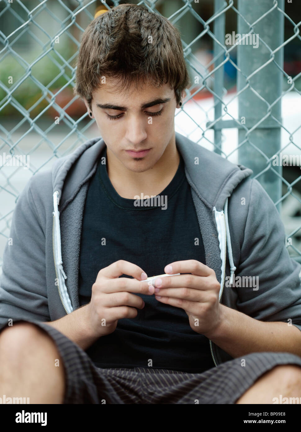 Teenage boy rolling a joint Stock Photo - Alamy
