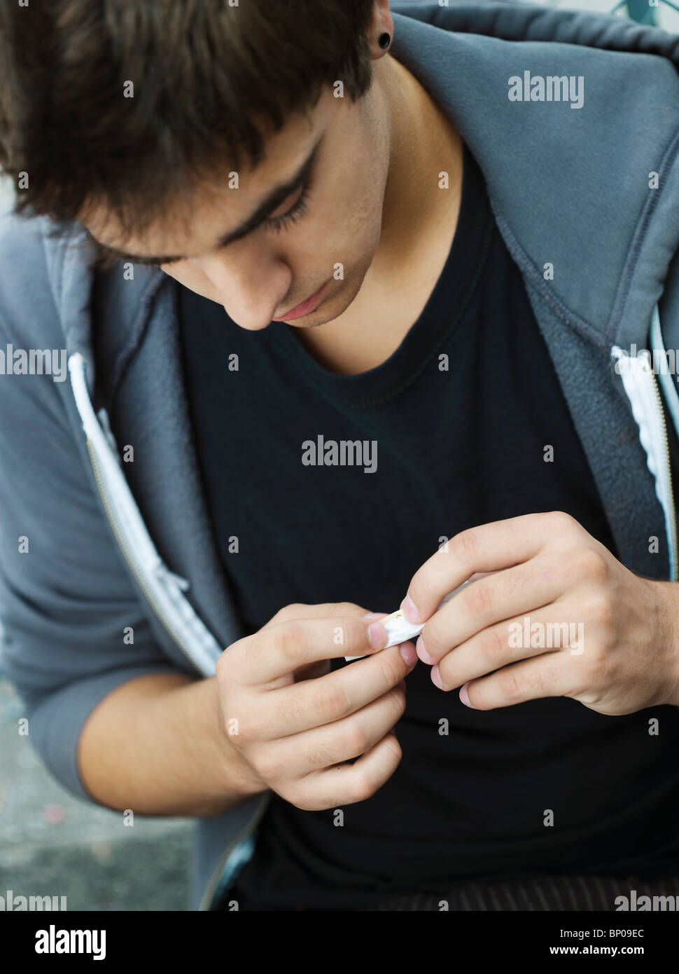 Teenage boy rolling a joint Stock Photo - Alamy