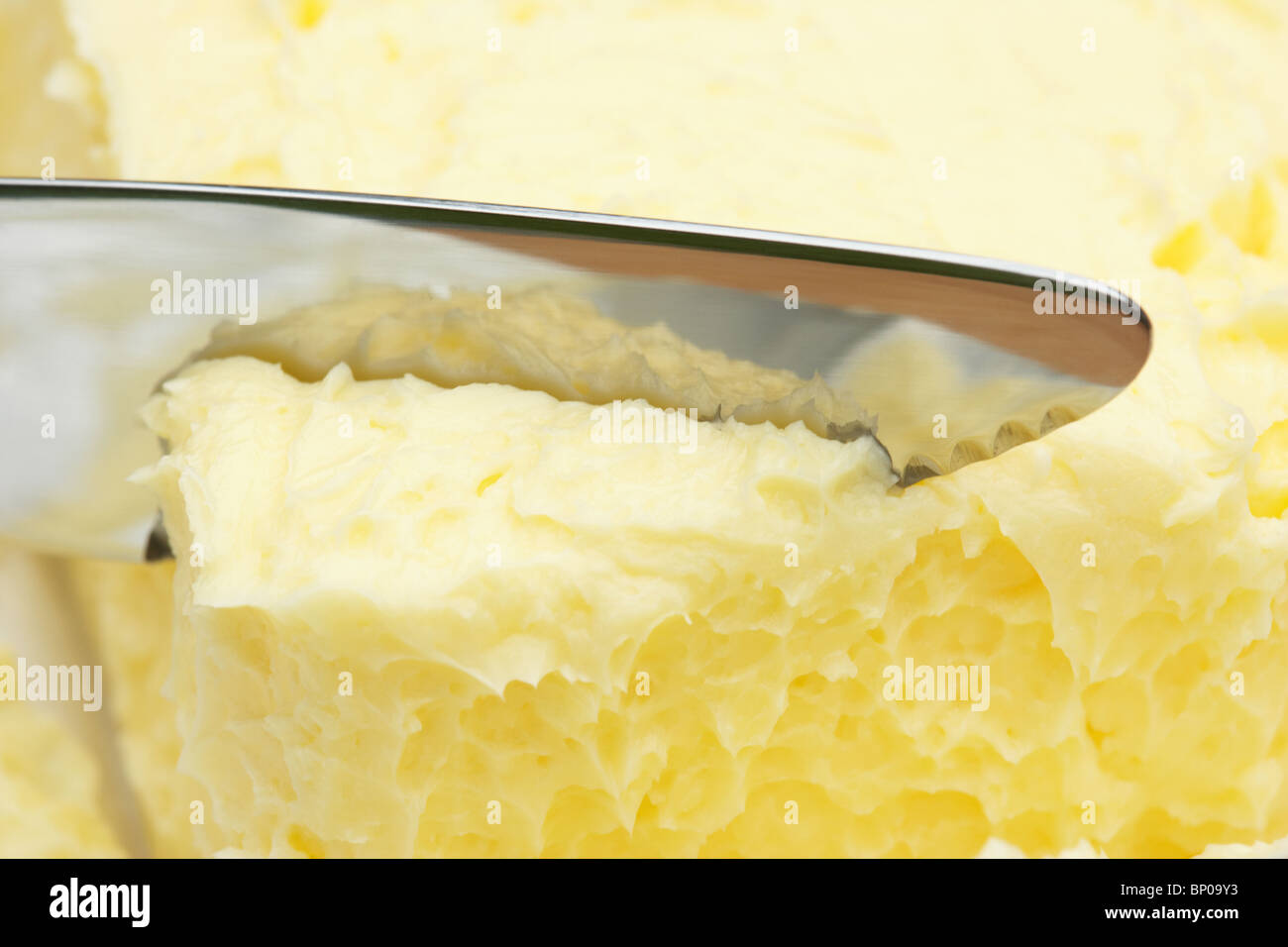 knife cutting a knob of butter off a block of 250g soft irish butter ...