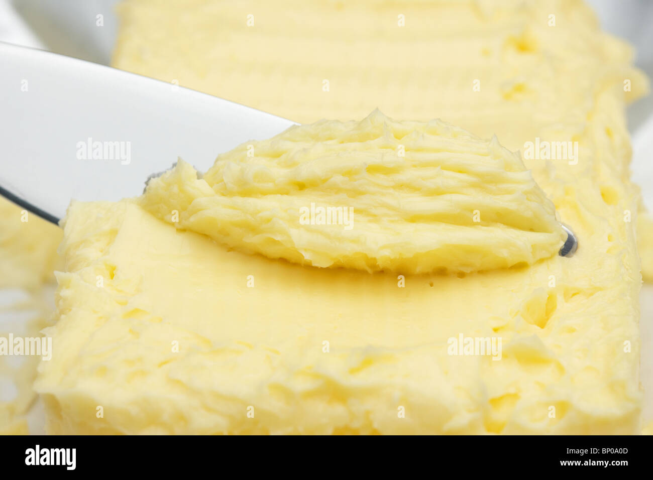 knife collecting a spread of butter off a block of 250g soft irish ...