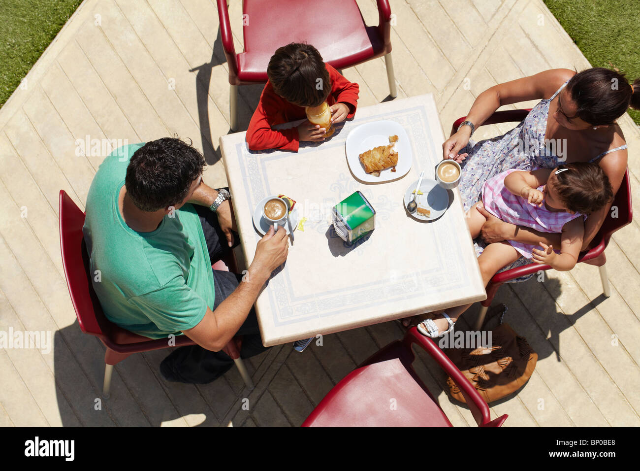 Close-up of family seated around table Stock Photo - Alamy