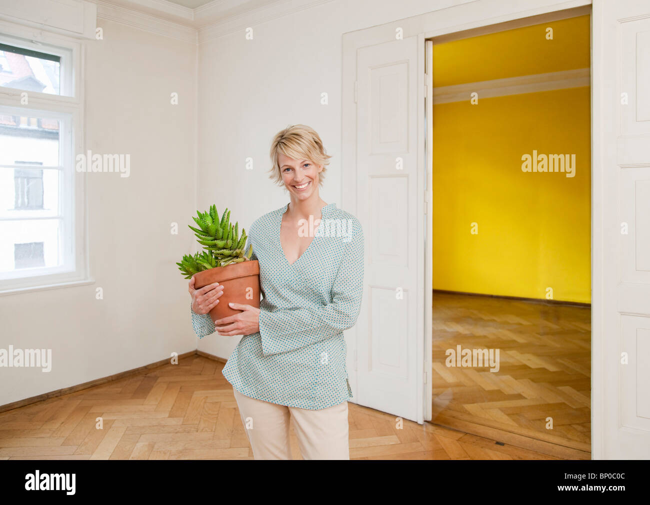 Young woman moving into home Stock Photo - Alamy
