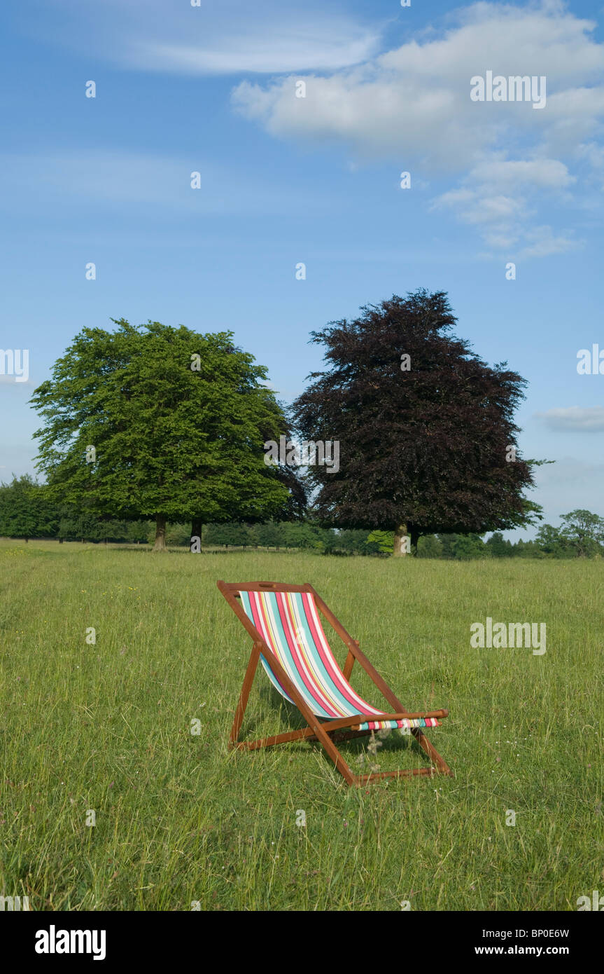 Deck chair in field Stock Photo - Alamy