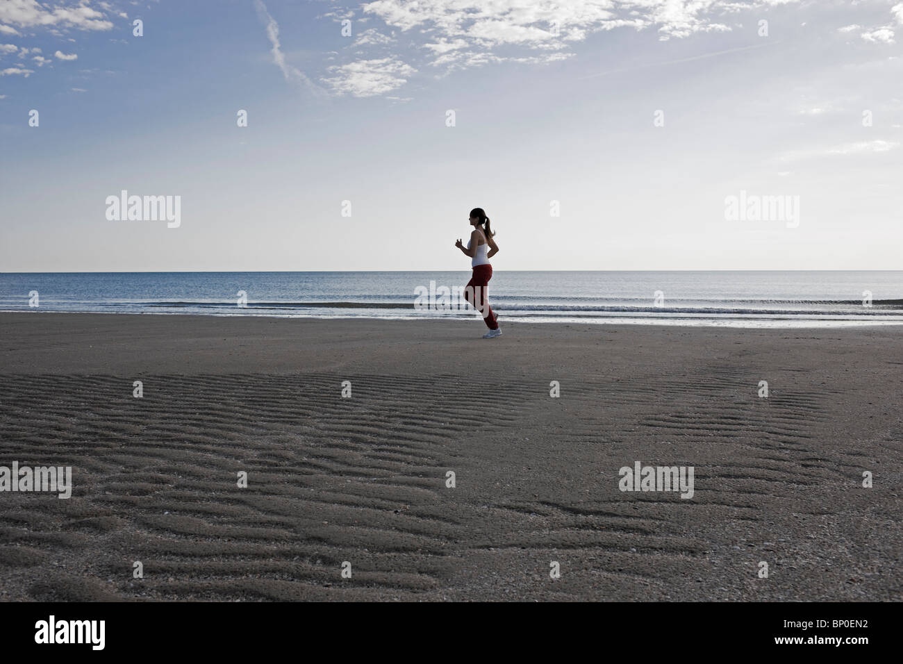 Woman jogging on the beach Stock Photo - Alamy