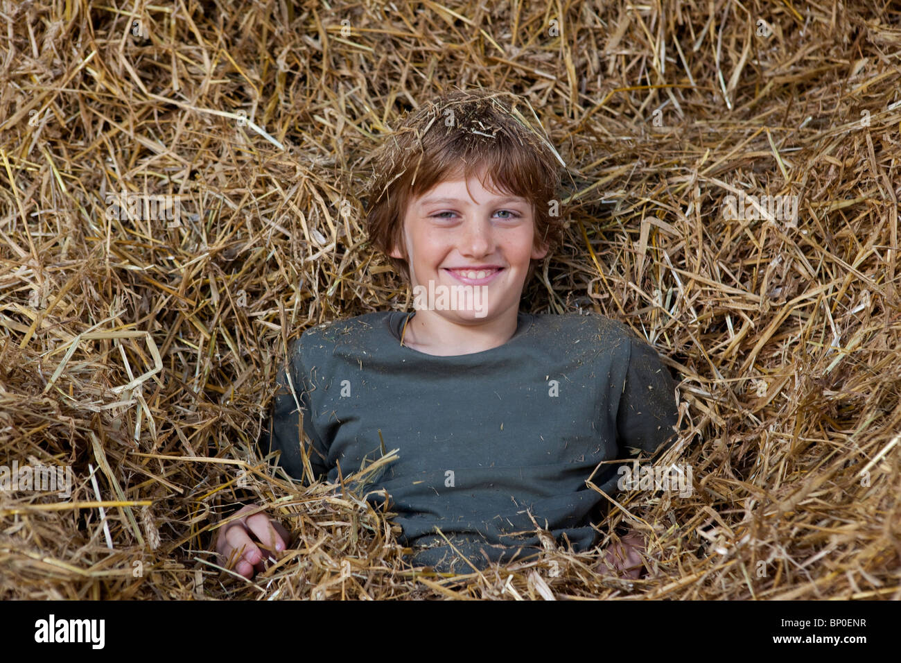 Boy in hay, smiling Stock Photo - Alamy