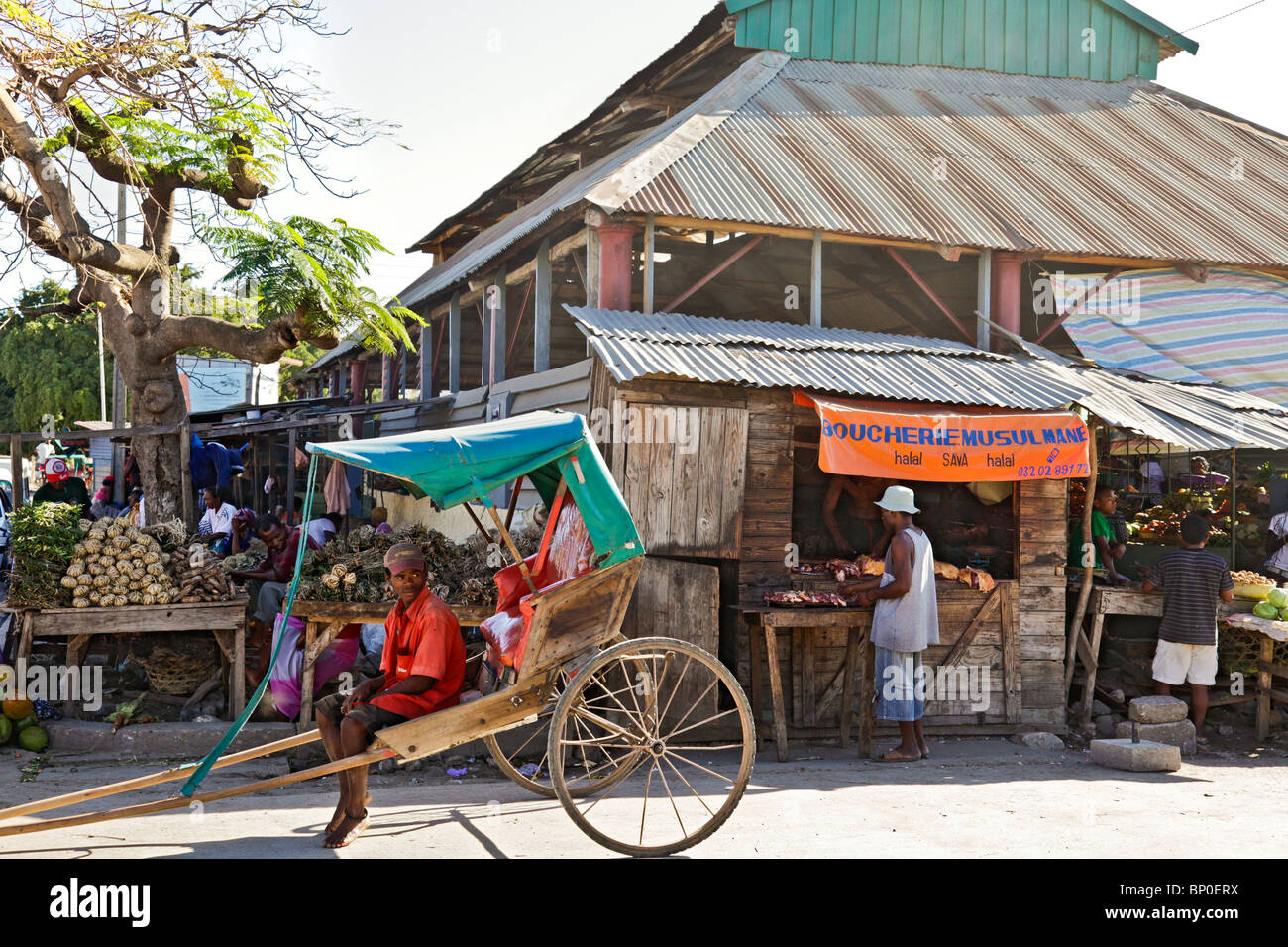 Pousse-pousse rickshaw and driver outside a Halal butcher's in the ...