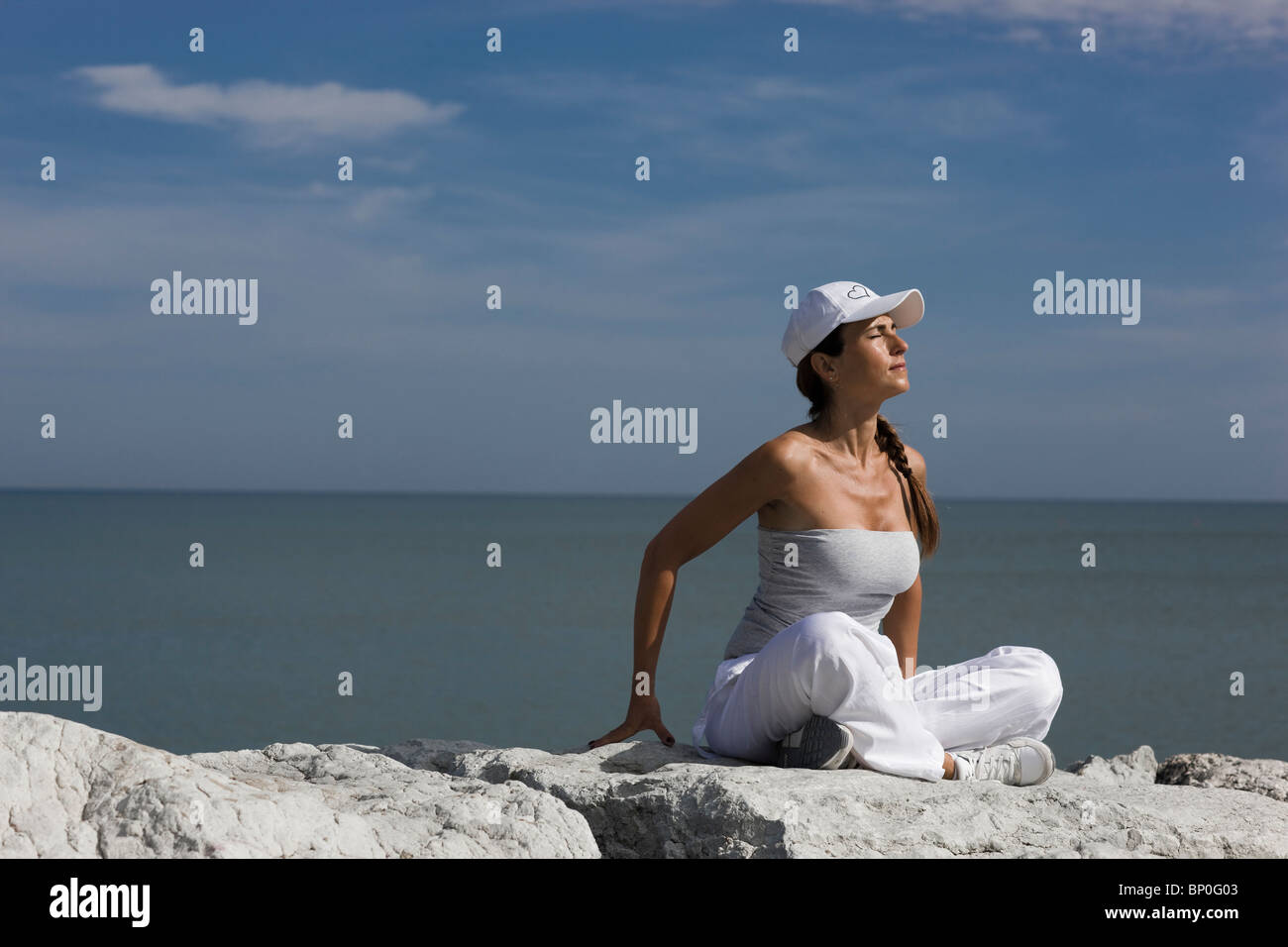 Woman seated on rocks hi-res stock photography and images - Alamy