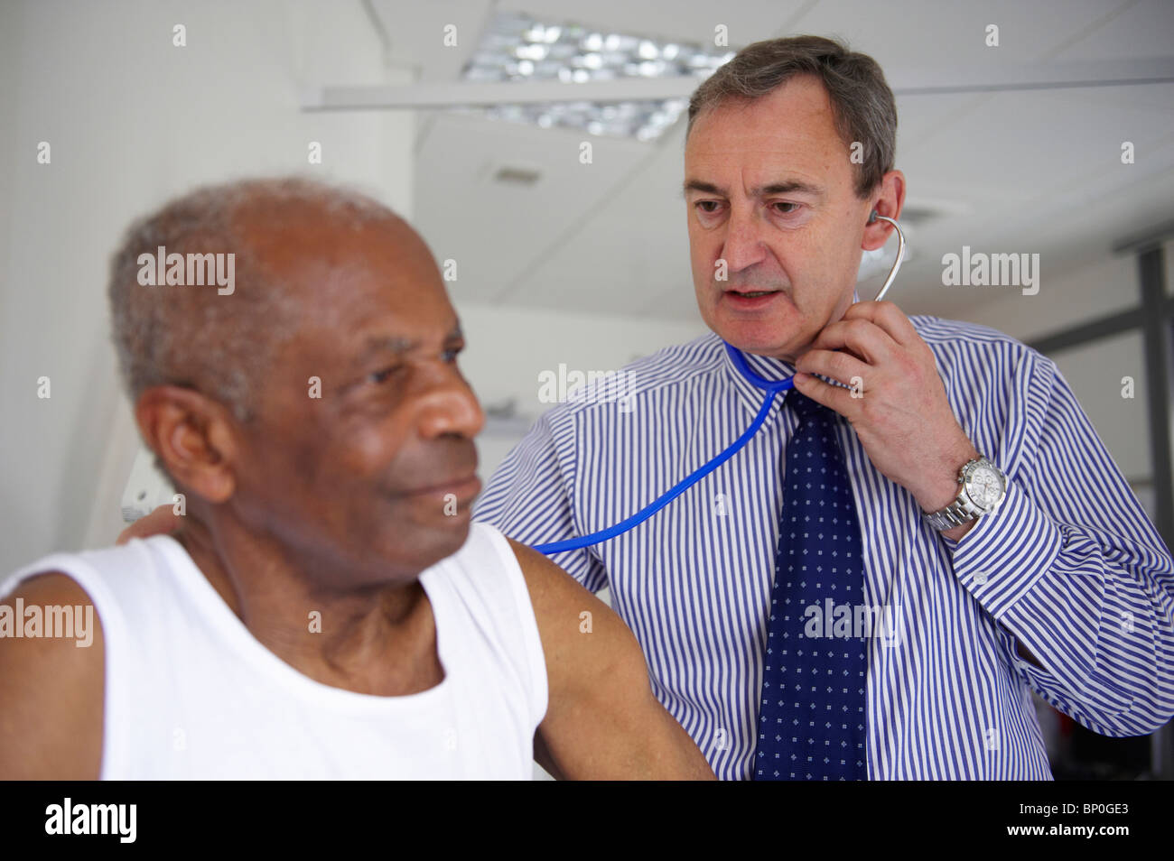 Doctor with stethoscope with elderly man Stock Photo - Alamy
