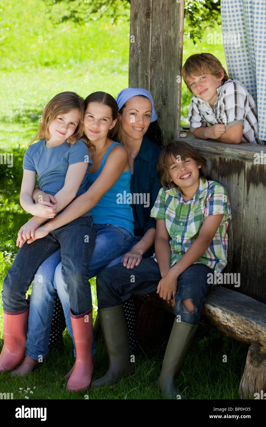 Family resting on shed, happy Stock Photo - Alamy