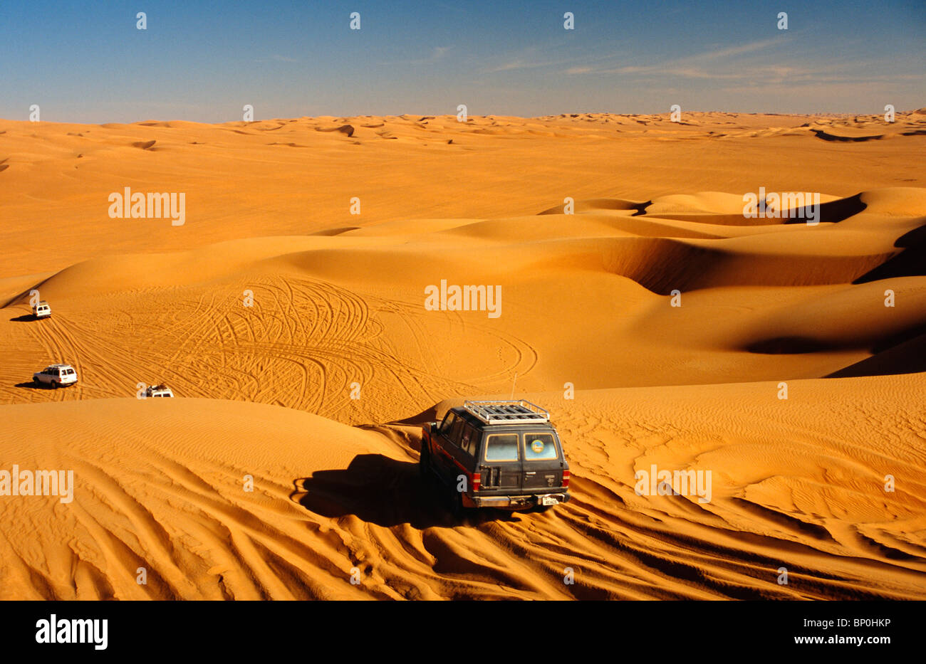 Libya, Fezzan, Edeyen Ubari. Tourists' 4WD vehicles head into the dunes ...