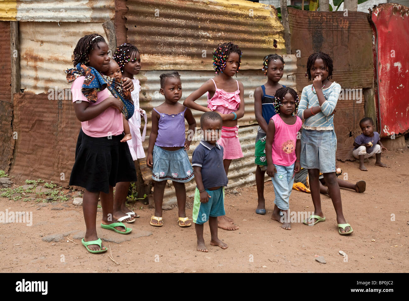 Mozambique, Maputo. A group of children crowd round the corrugated ...