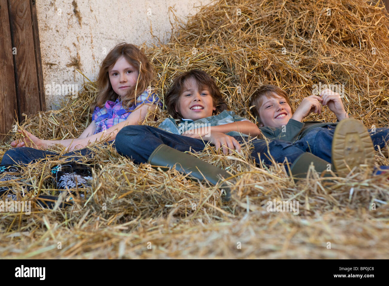 Three kids resting in hay Stock Photo - Alamy