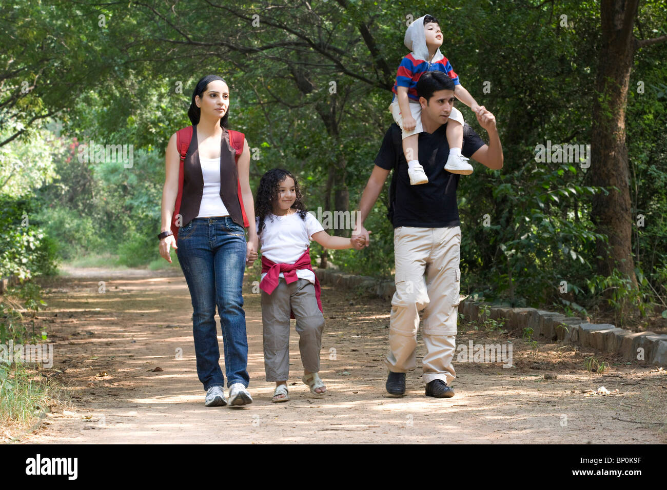 Family going for a walk in a park Stock Photo - Alamy