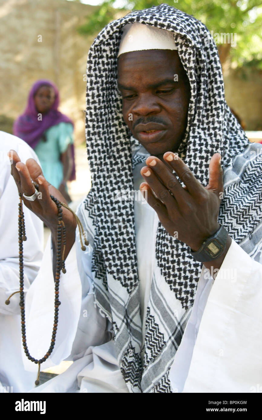 Man prays in Chad holding his tasbih, or Muslim `rosary beads.' Stock ...