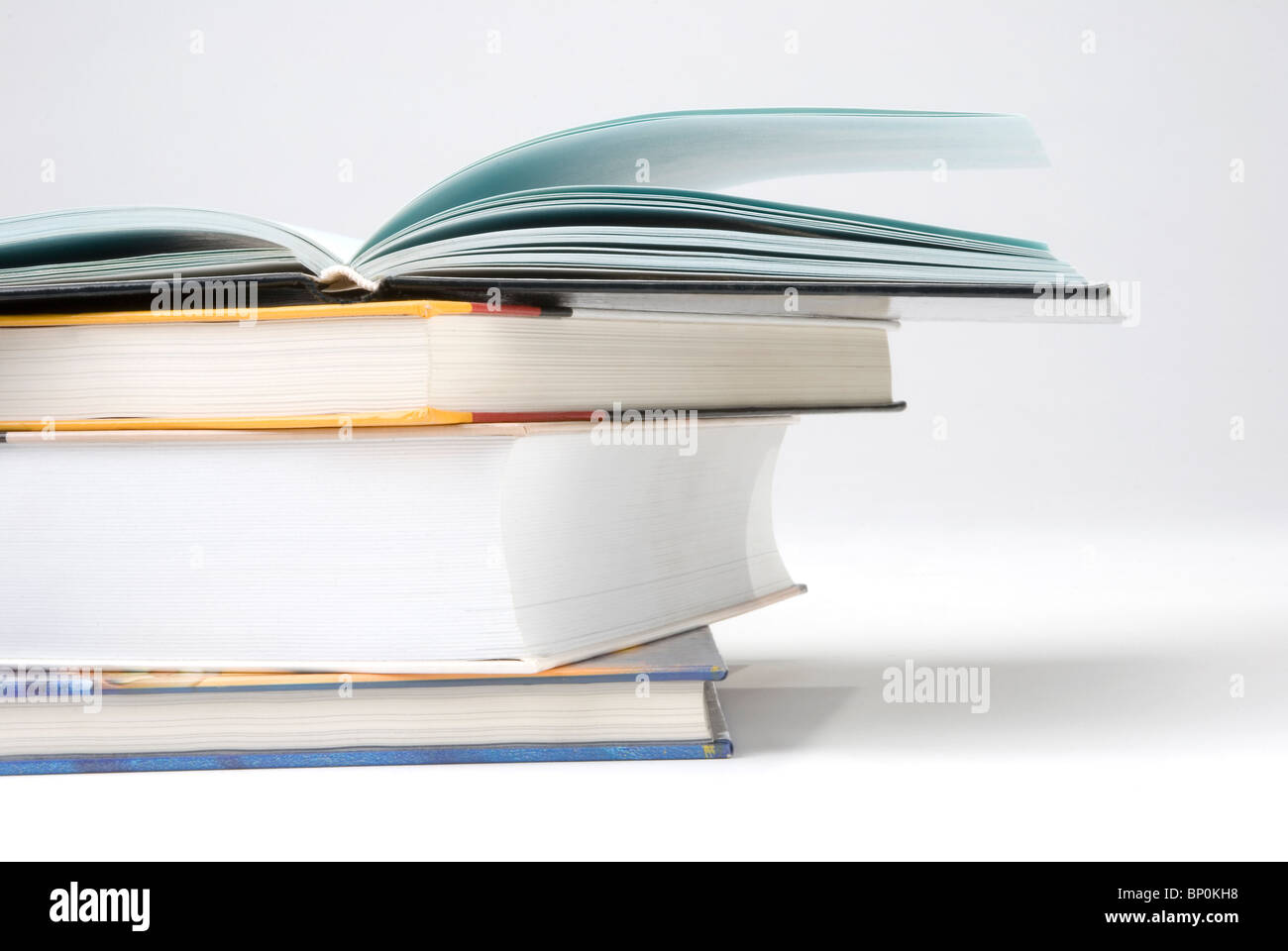 Three book and one opened on white background Stock Photo - Alamy