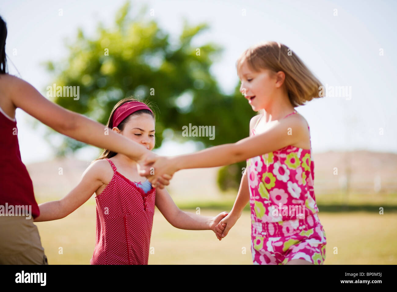 Girls holding hands dancing in a circle Stock Photo - Alamy