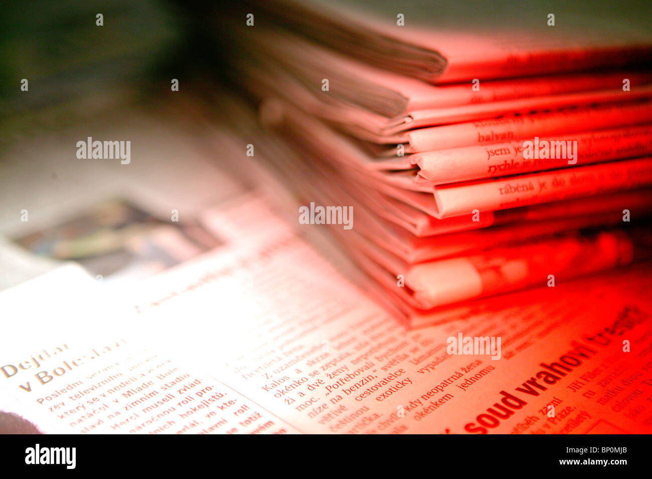 A detail of a pile of newspaper in red light Stock Photo - Alamy