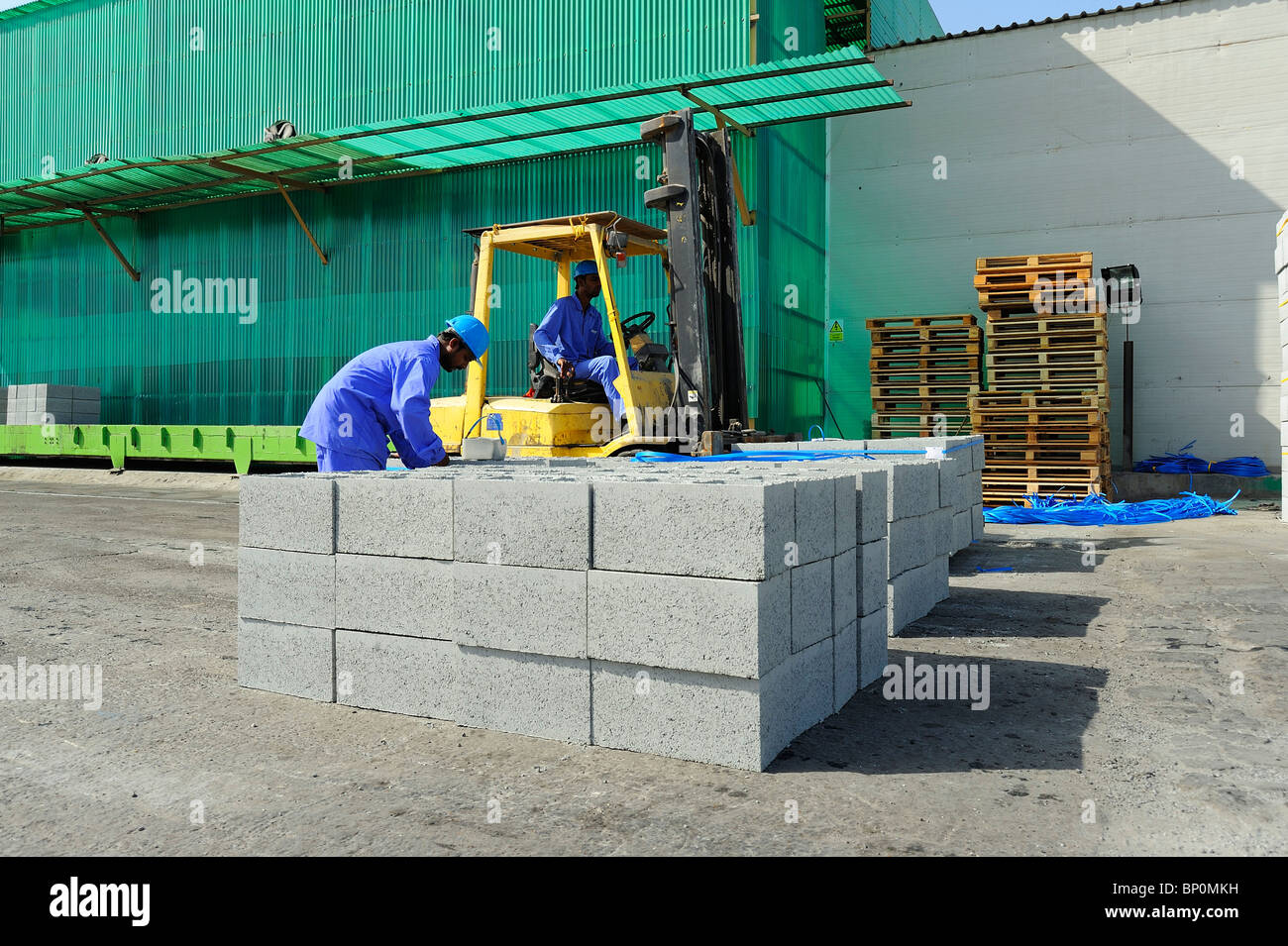 workers arranging cement blocks Stock Photo - Alamy