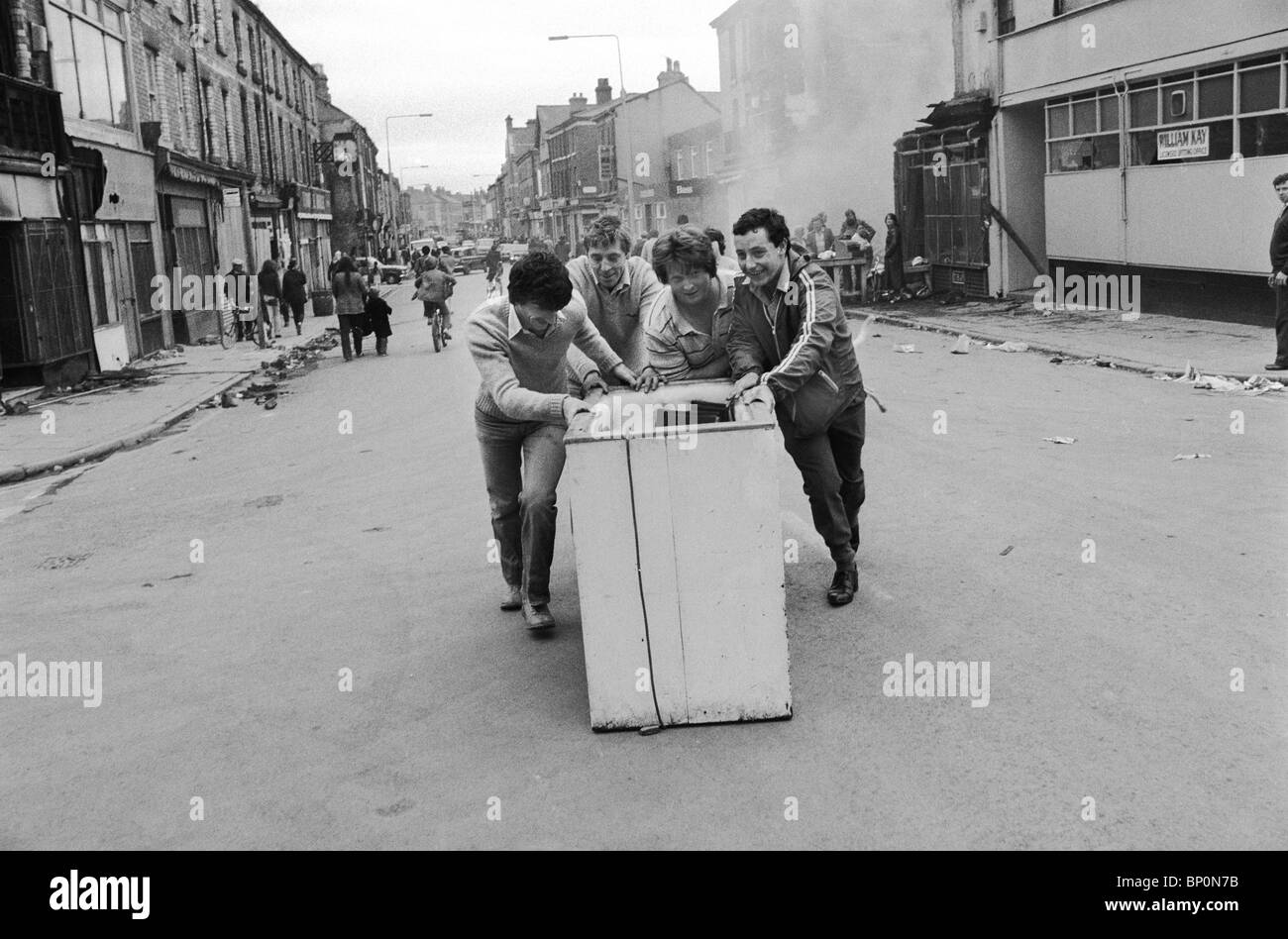 Toxteth Riot 1980s UK. Men looting pushing sink unit down the main ...