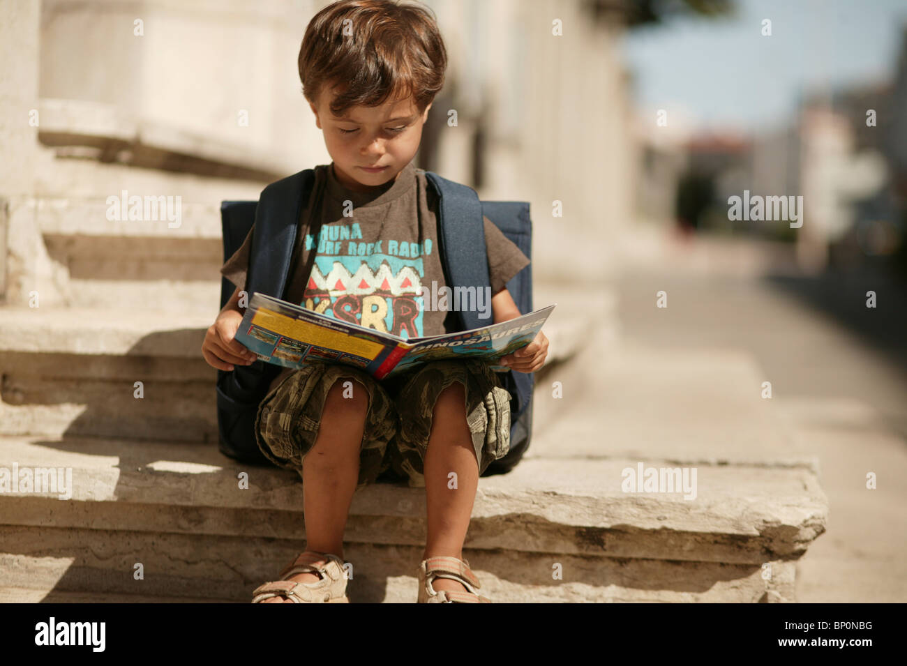 Boy reading in the street Stock Photo - Alamy