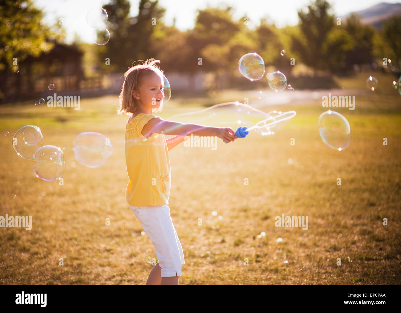 Young girl making large bubble in park Stock Photo - Alamy