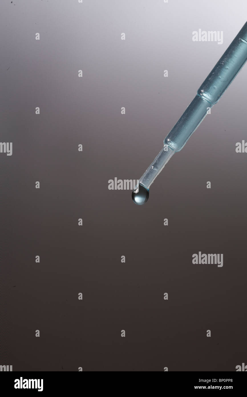 Drop of blue liquid on the end of a pipette Stock Photo - Alamy