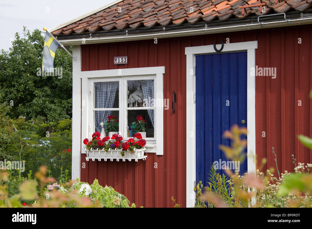 Swedish red country cottage with blue door Stock Photo - Alamy