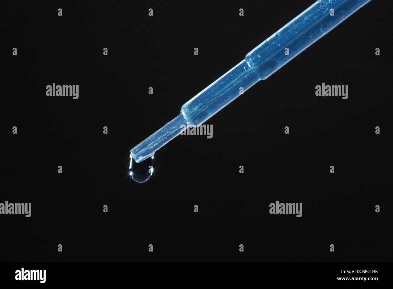 Drop of blue liquid on the end of a pipette Stock Photo - Alamy